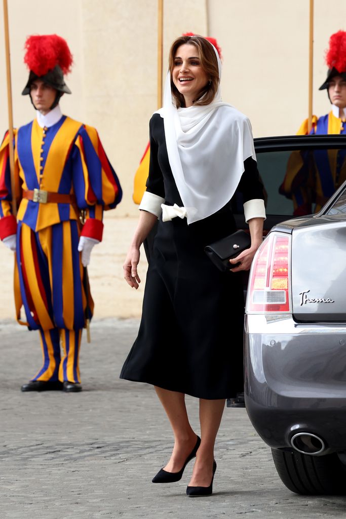 Queen Rania is elegant in two-piece look and dark glasses on sombre ...
